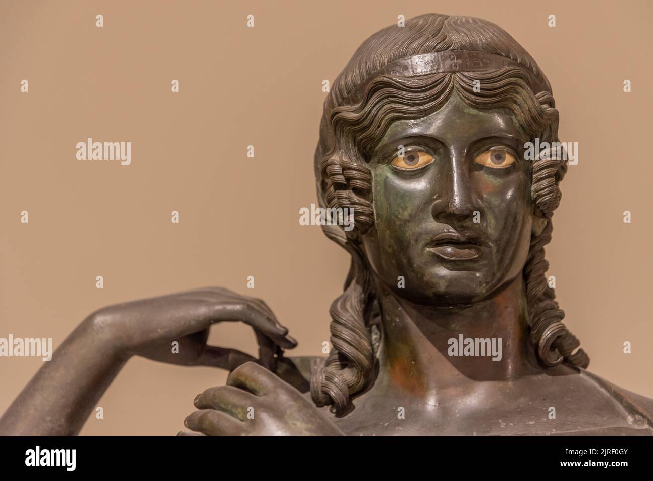 Close-up on face of ancient metal statue representing a girl with ...