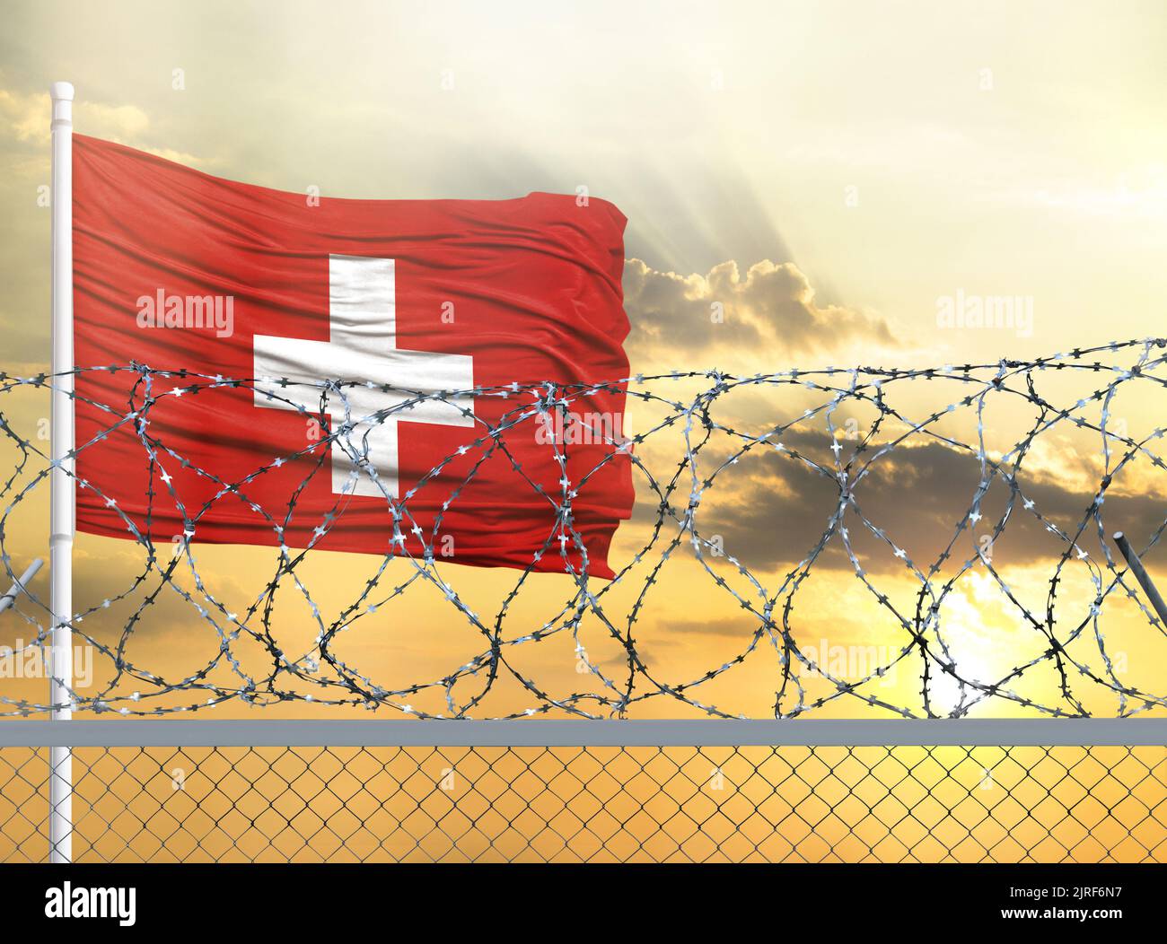 Flagpole with the flag of Switzerland against the sky and behind a ...