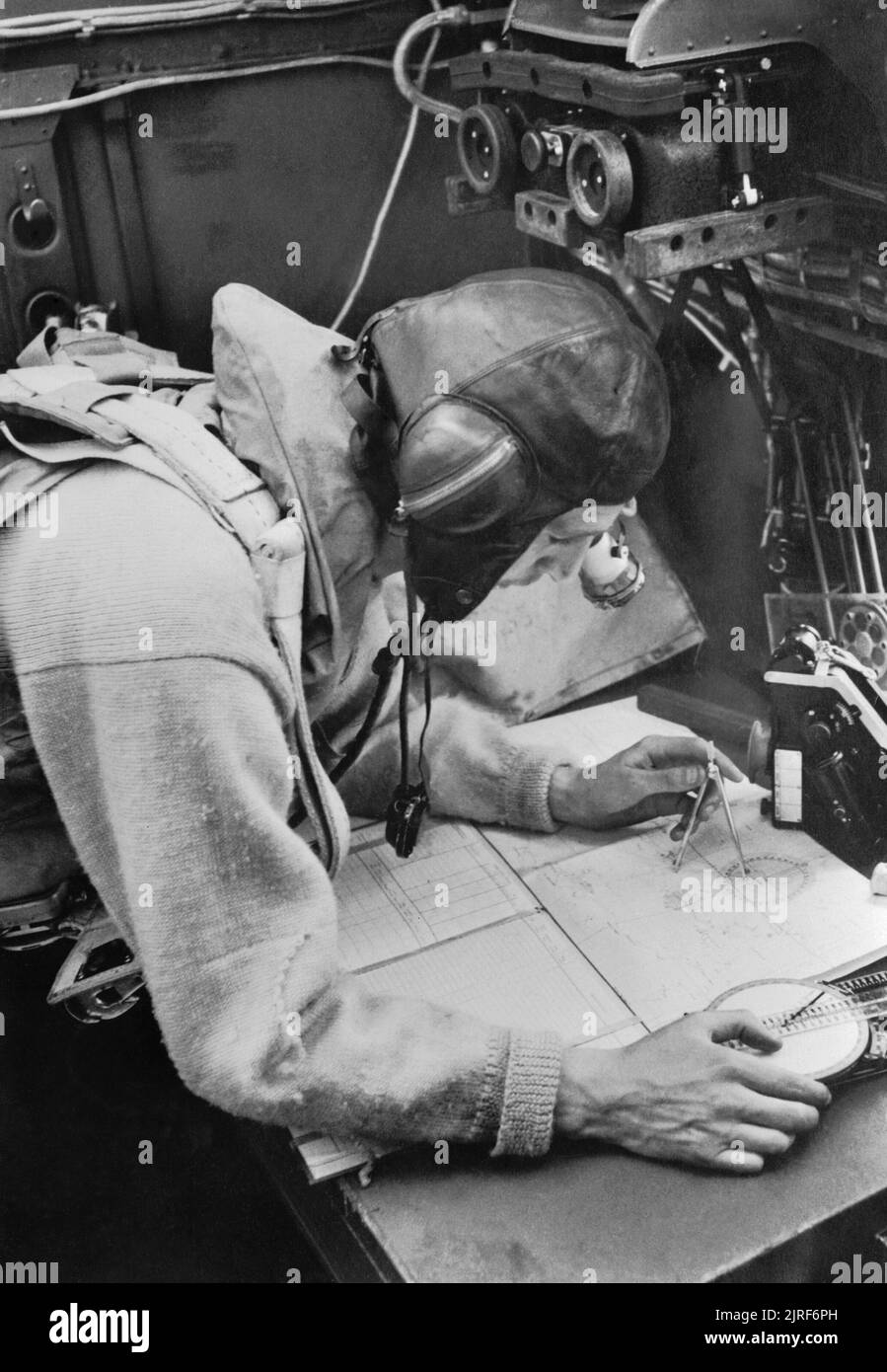 A Cecil Beaton photograph of the navigator working at his chart table ...