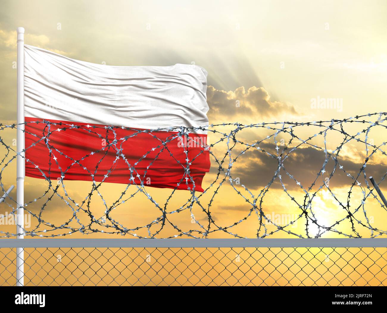 Flagpole with the flag of Poland against the sky and behind a fence ...