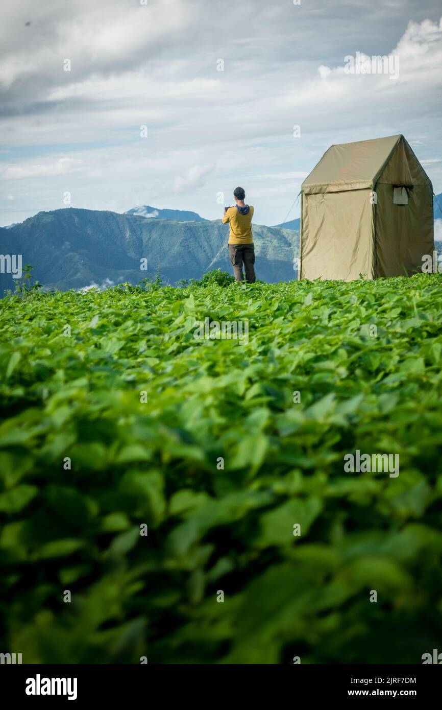 Uttarakhand India. A man camping and taking a photograph of the valley ...