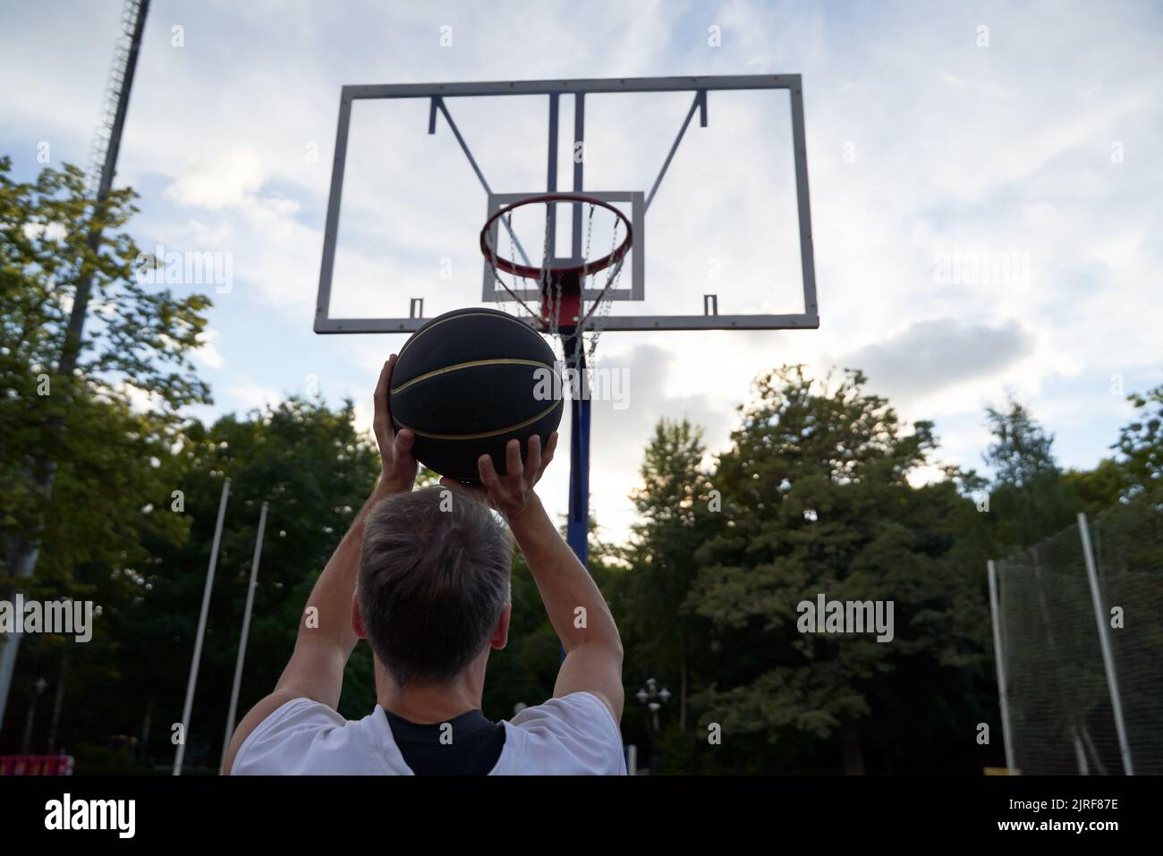 Man is throwing ball to the hoop. Training of basketball on the street ...