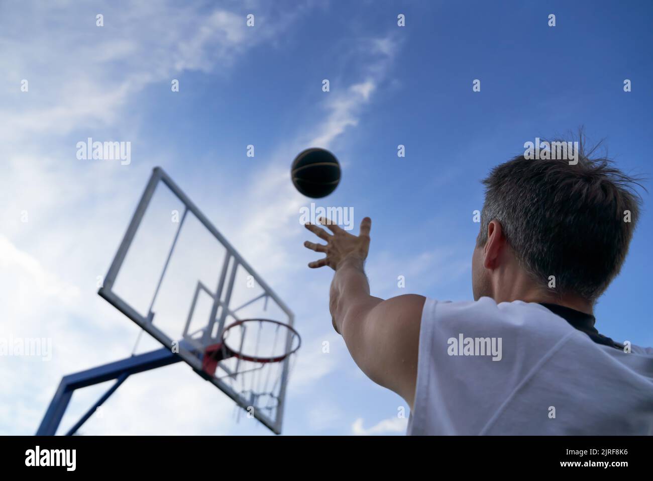 Man is throwing ball to the hoop. Training of basketball on the street ...