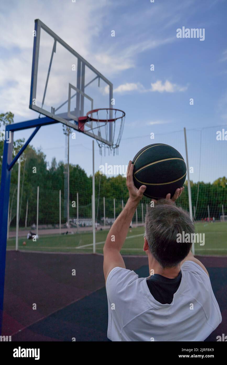 Man is throwing ball to the hoop. Training of basketball on the street ...