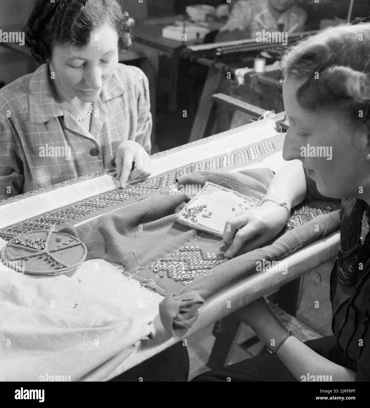 In the workrooms of the fashion designer Norman Hartnell in London, two ...