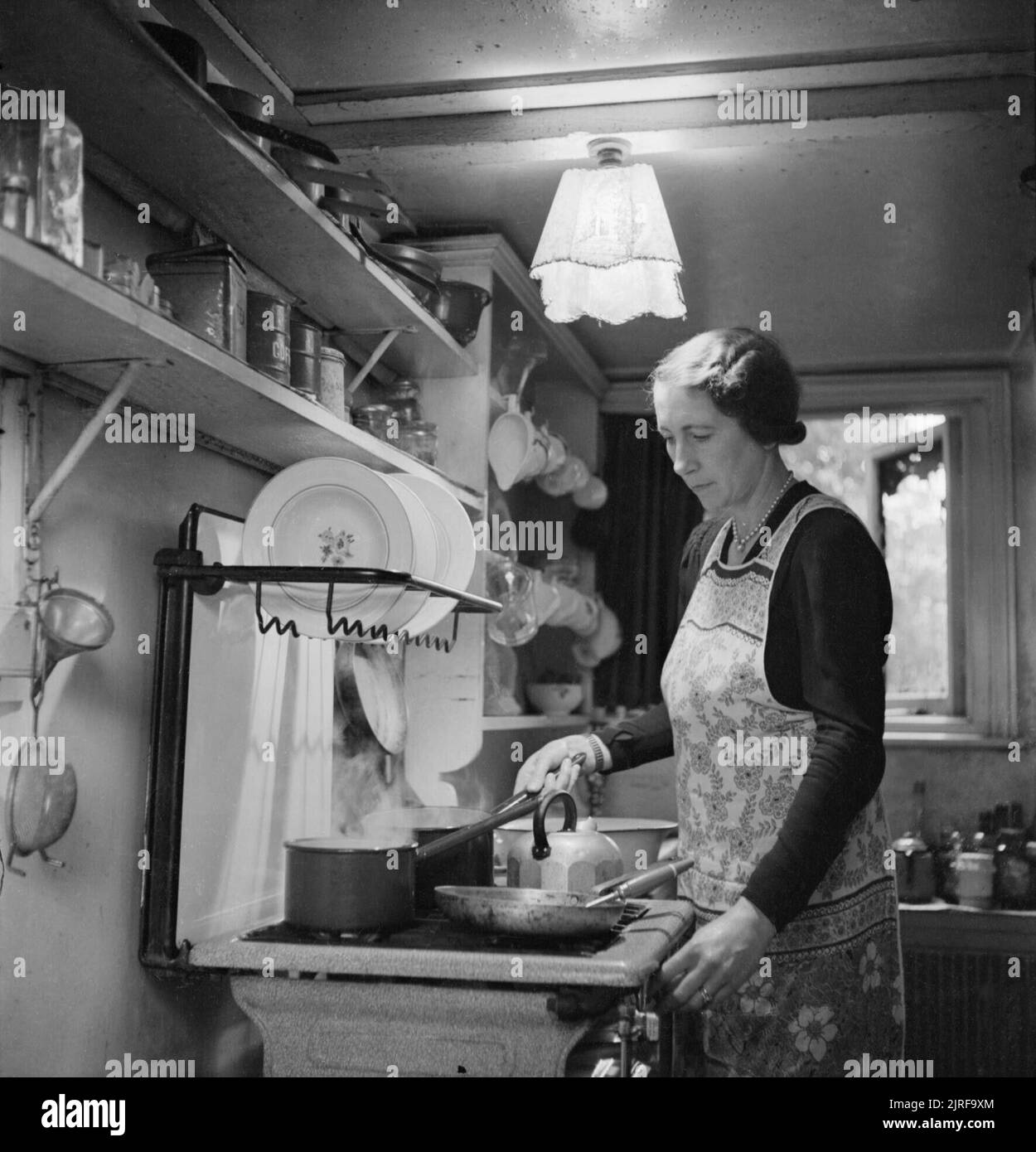 Mrs M Hasler cooks breakfast for her invalid husband in their home in ...