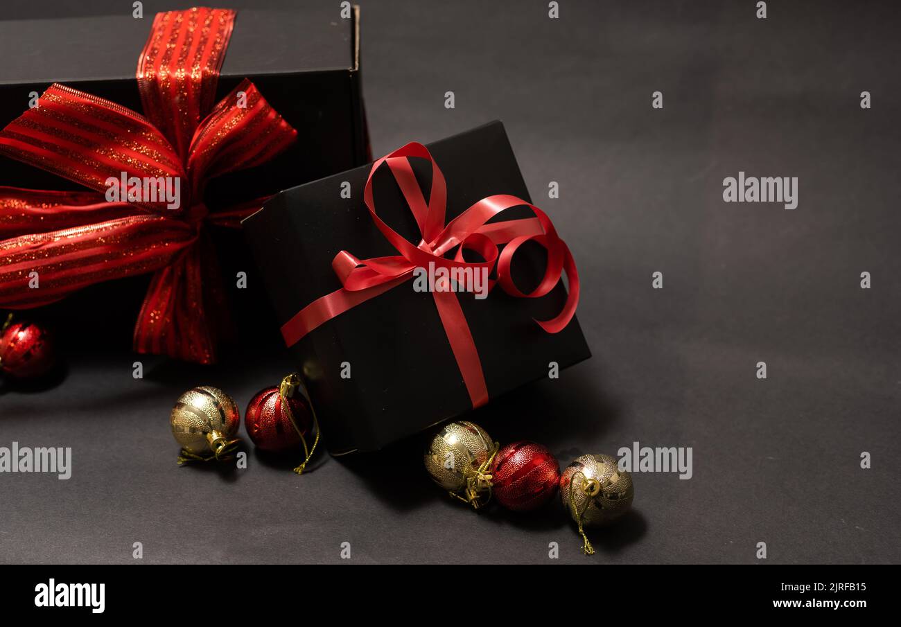 black gift box, balls, red Christmas decorations on the dark wooden ...