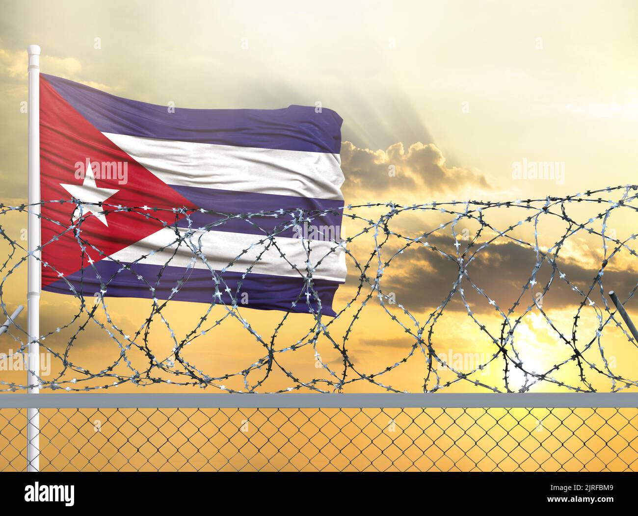 Flagpole with the flag of Cuba against the sky and behind a fence with ...