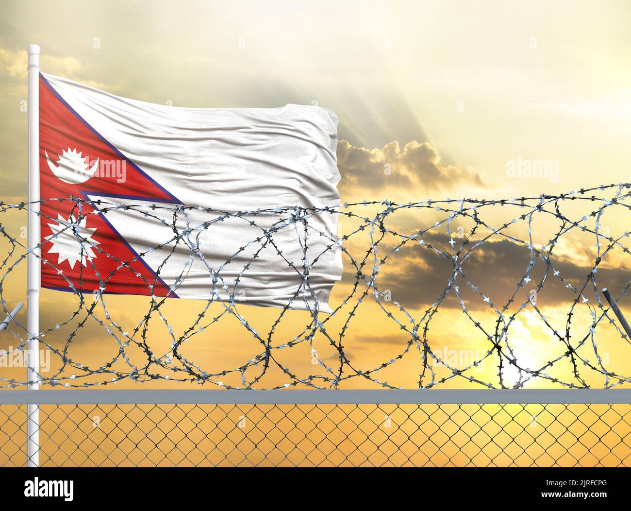 Flagpole with the flag of Nepal against the sky and behind a fence with ...