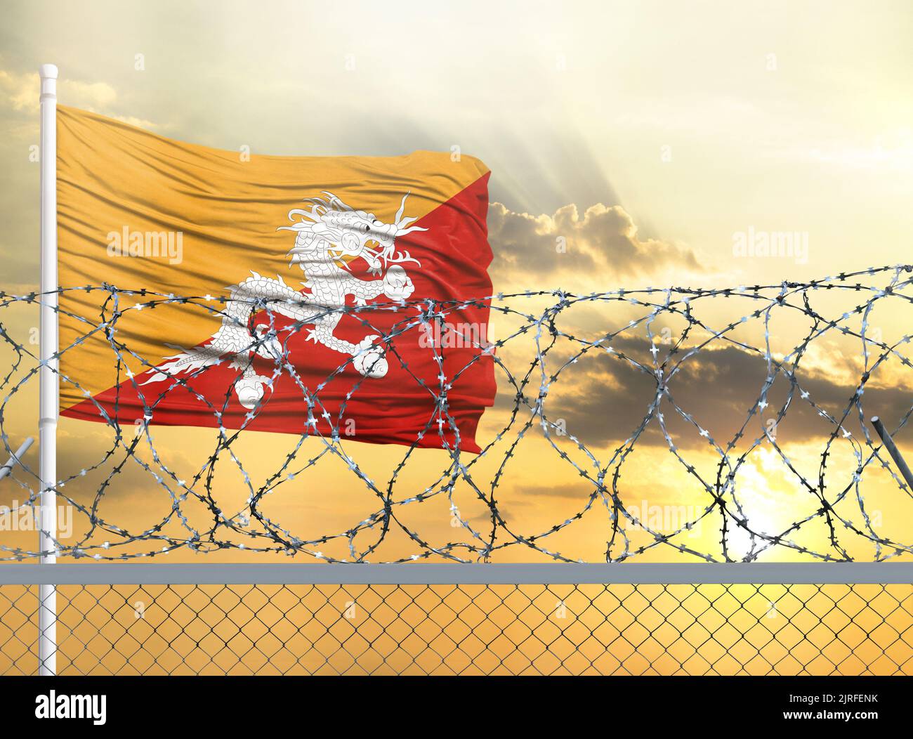 Flagpole with the flag of Butane against the sky and behind a fence ...