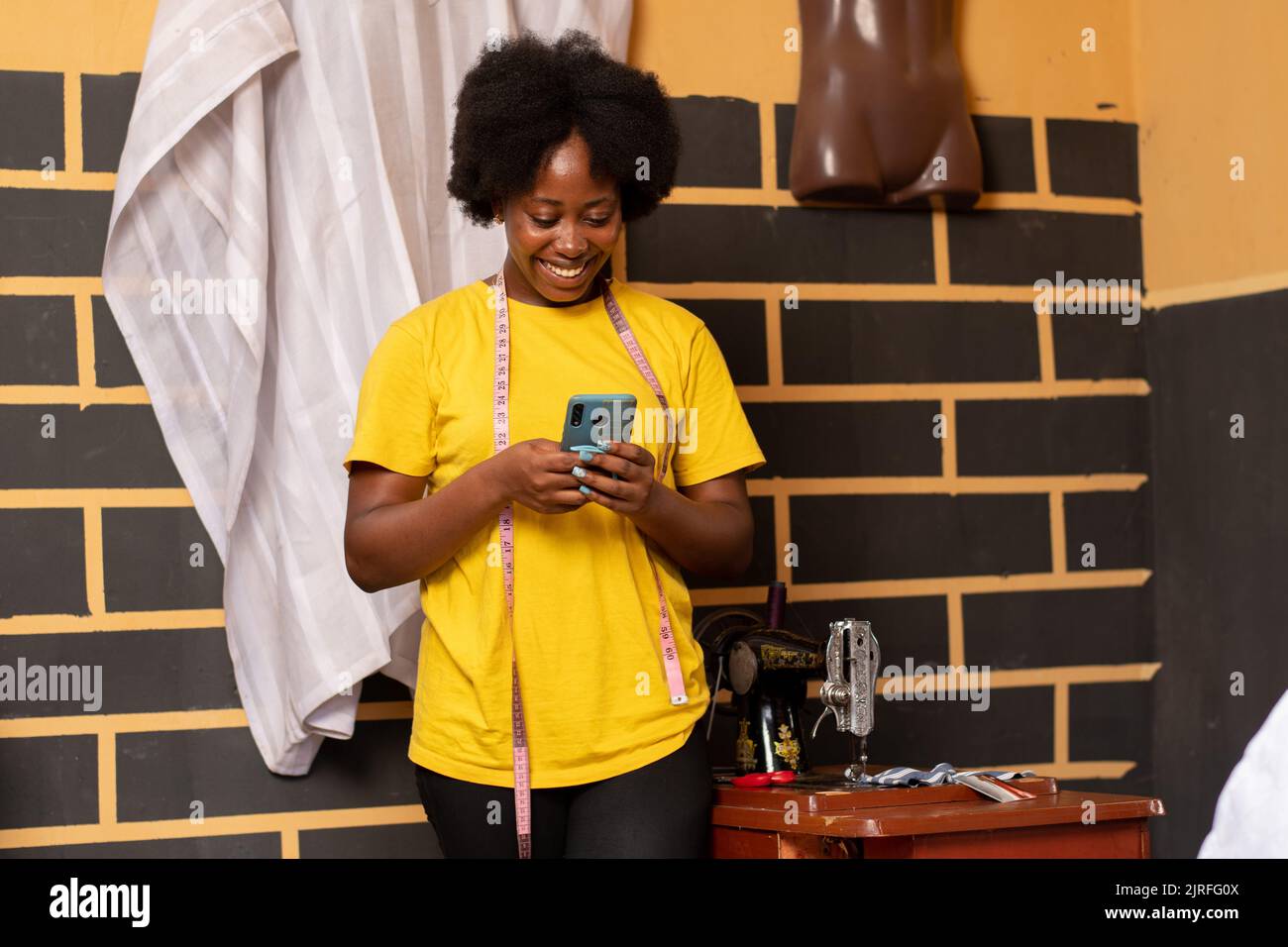 female african tailor using her phone Stock Photo - Alamy