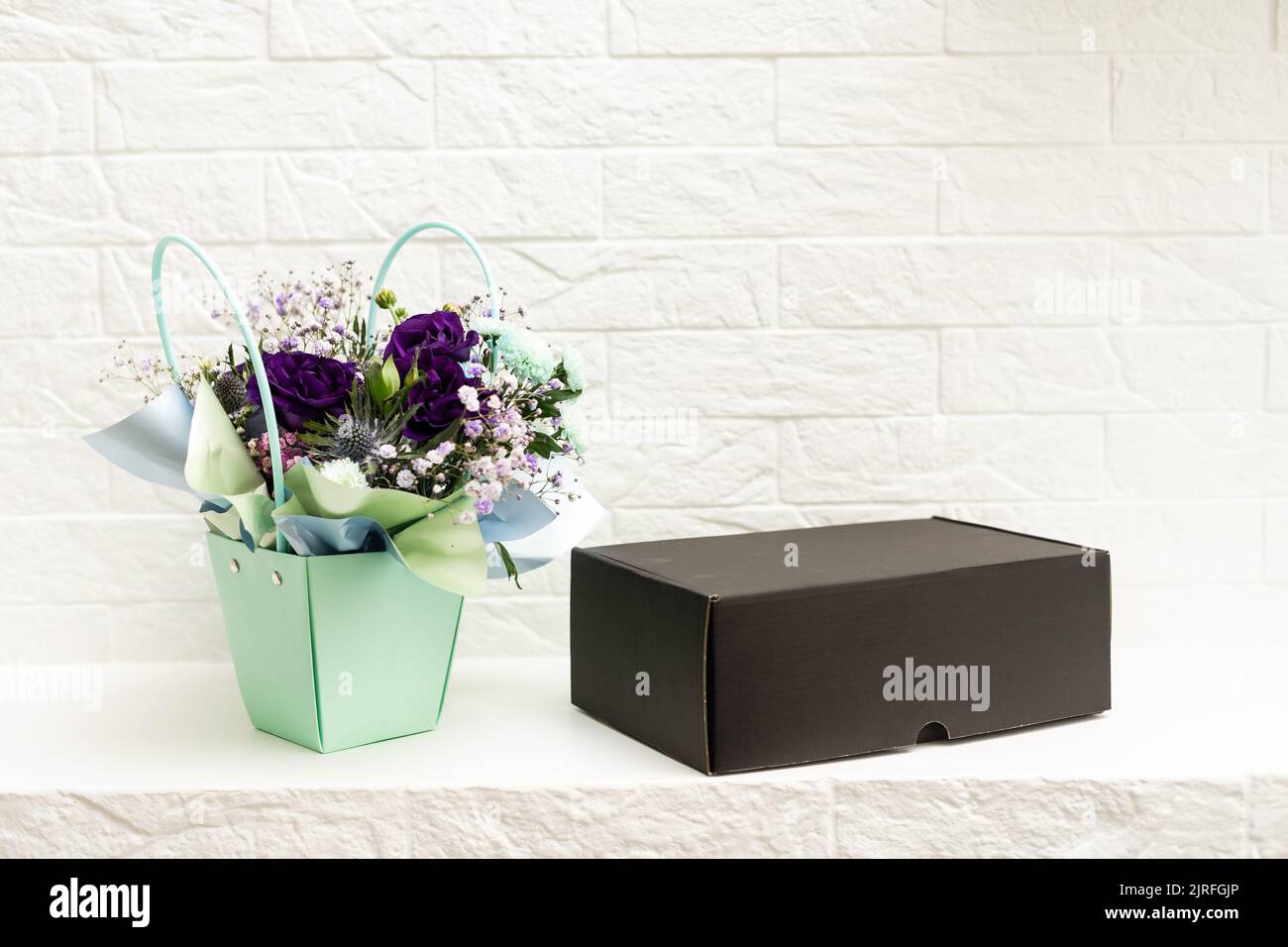 black gift box on bouquet of flowers Stock Photo - Alamy