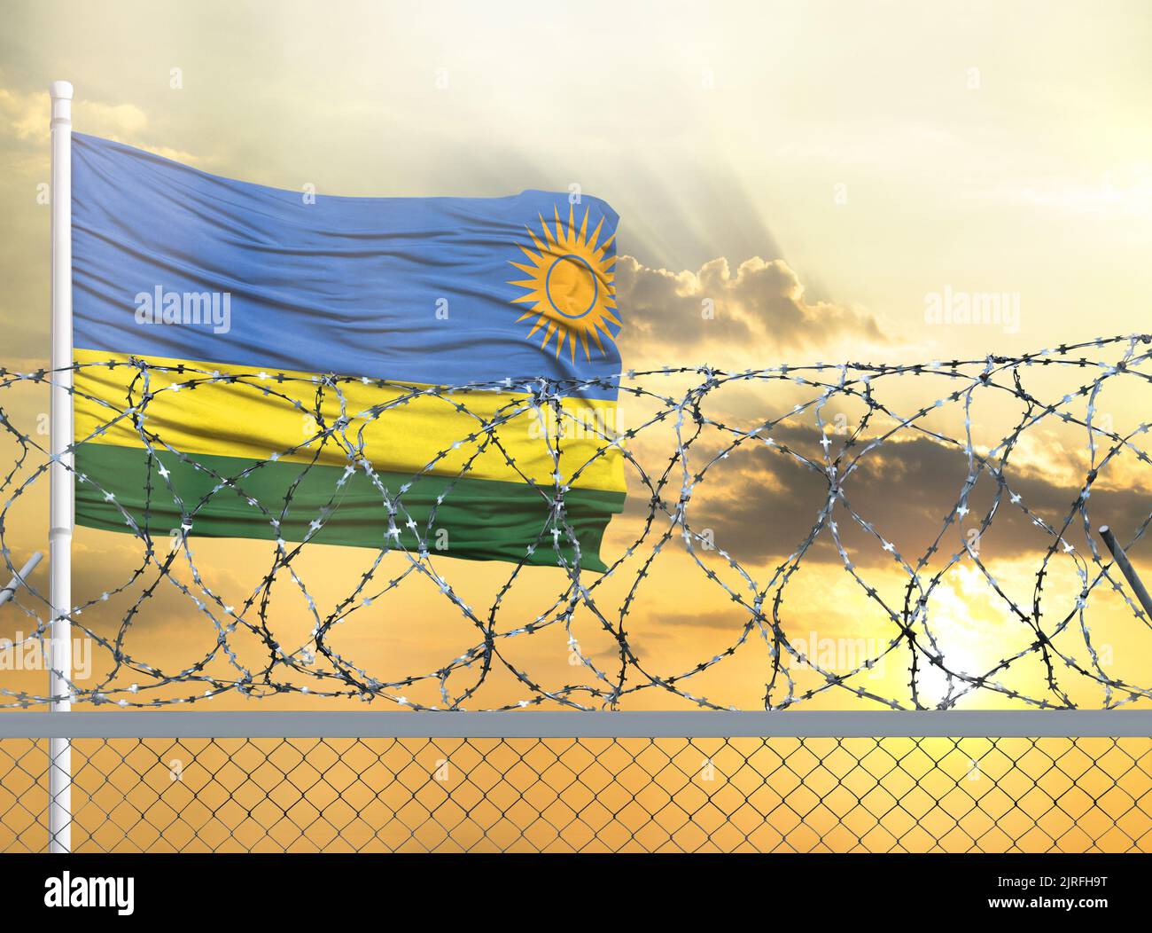 Flagpole with the flag of Rwanda against the sky and behind a fence ...