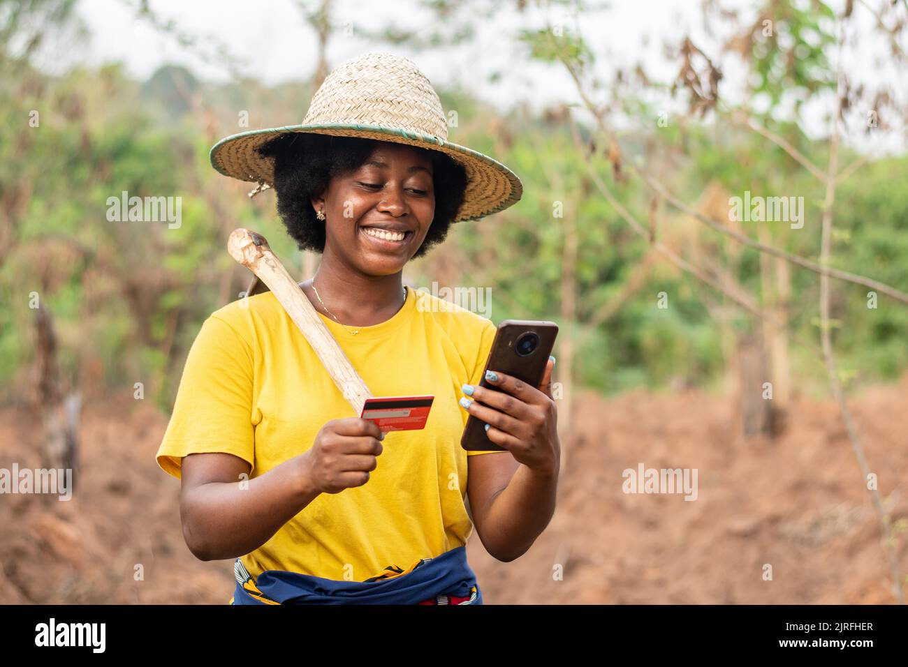 happy african farmer using her phone and credit card Stock Photo - Alamy