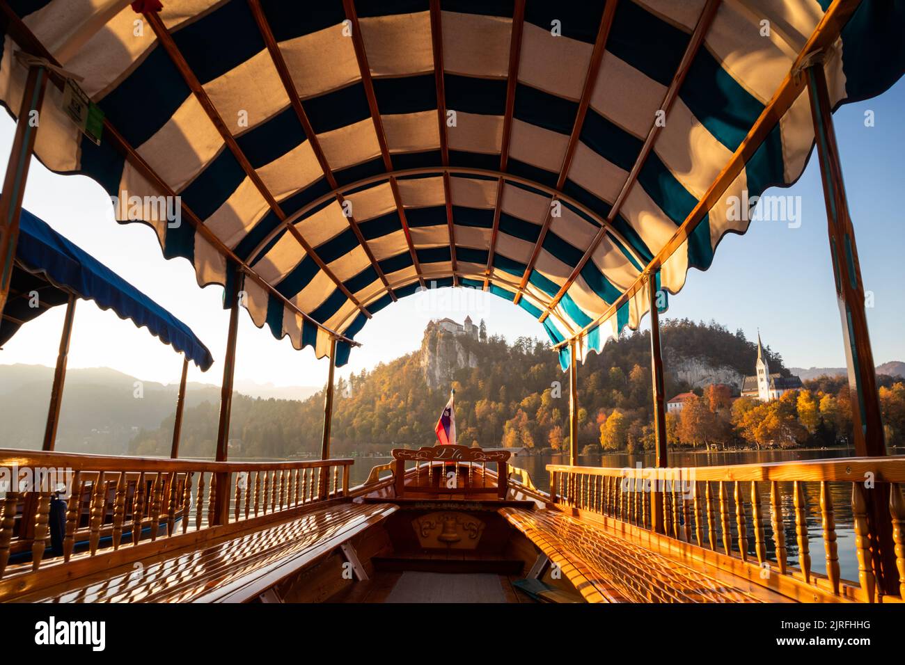 Interior of traditional pletna boat on lake Bled with old castle on the ...