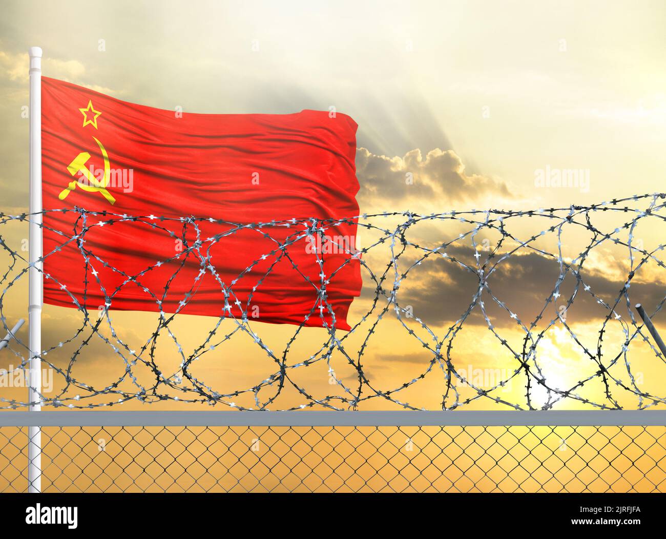 Flagpole with the flag of USSR against the sky and behind a fence with ...