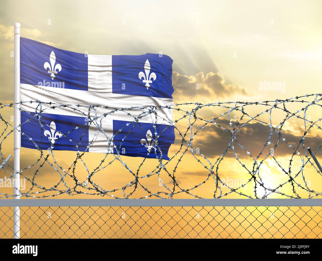 Flagpole with the flag of Quebec against the sky and behind a fence ...