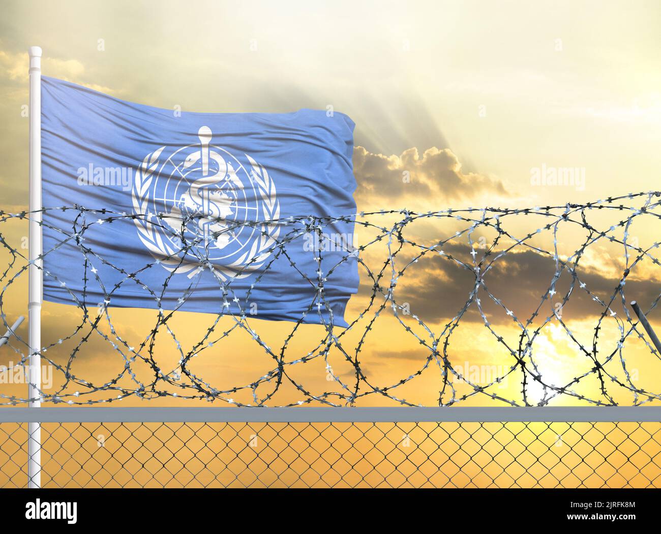 Flagpole with the flag of WHO against the sky and behind a fence with ...
