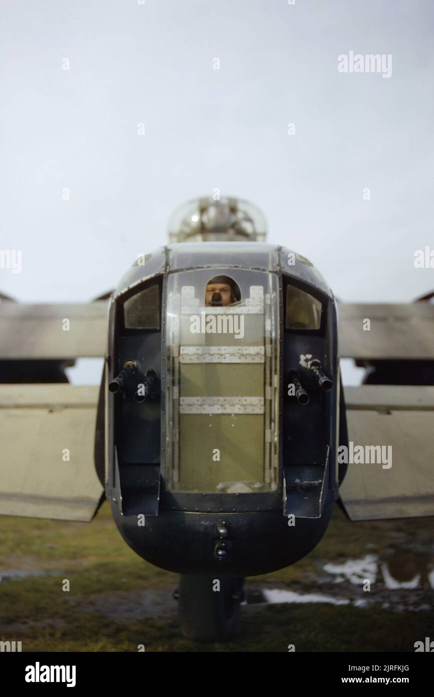 The rear gunner of a Lancaster of No. 44 Squadron peeks out through a ...