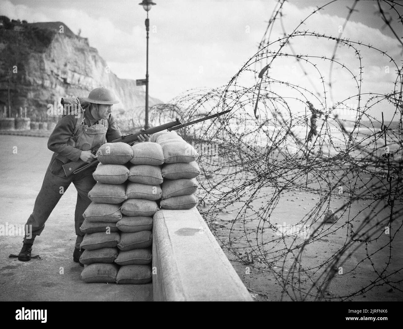 Posed portrait of a soldier with rifle and bayonet standing watch ...