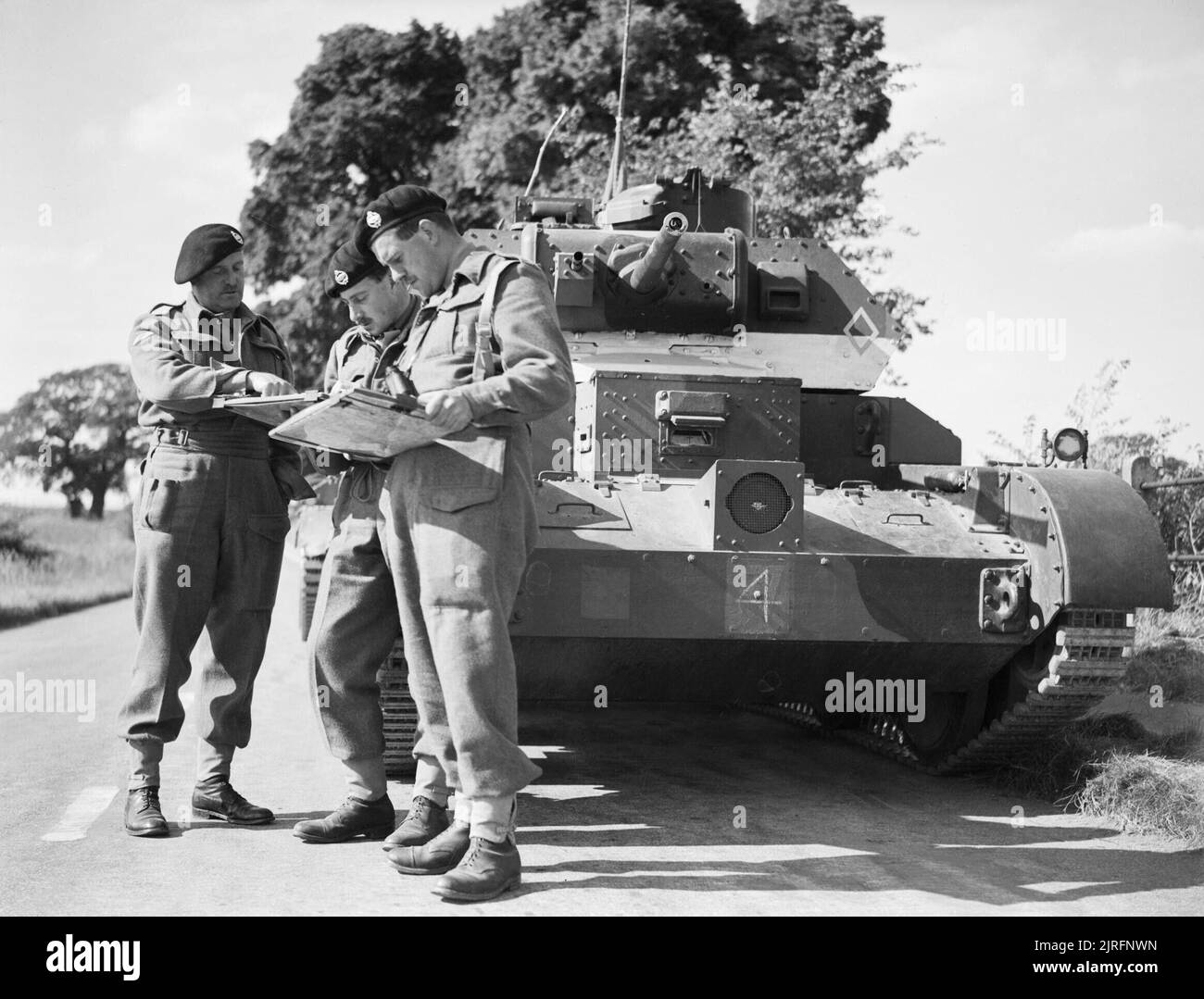 Royal Tank Regiment officers confer in front of a Cruiser Mk IVA tank ...