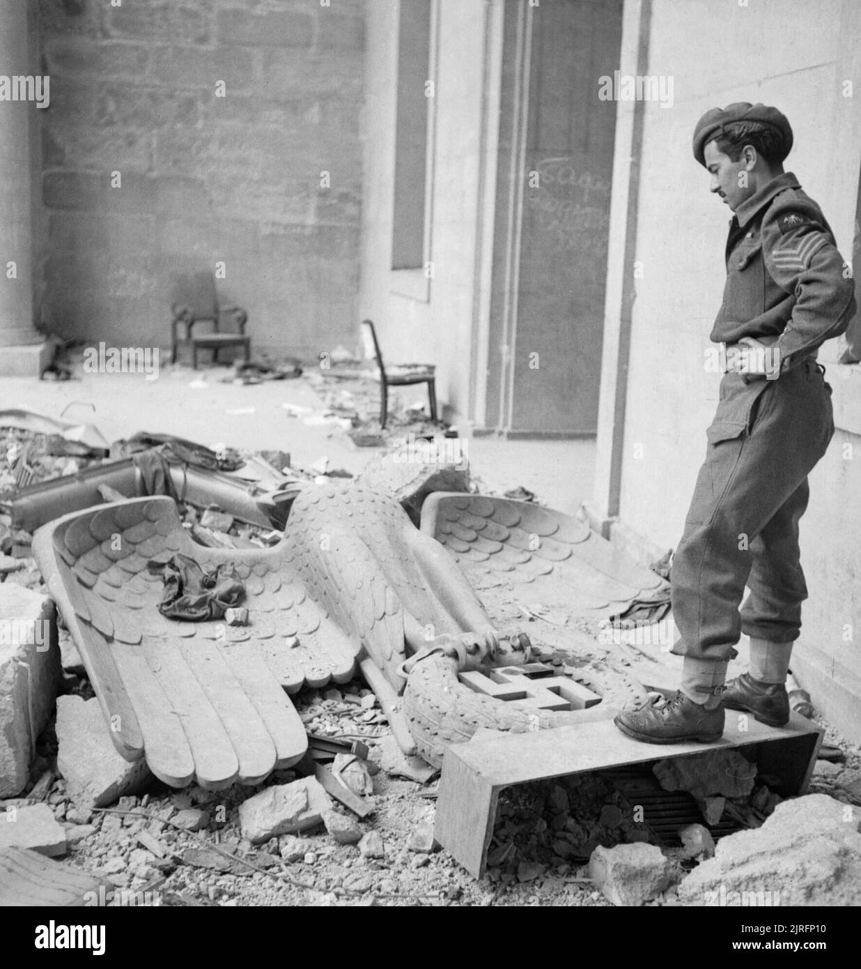 Sergeant R S Baker of the Army Film & Photographic Unit (AFPU) looks at ...