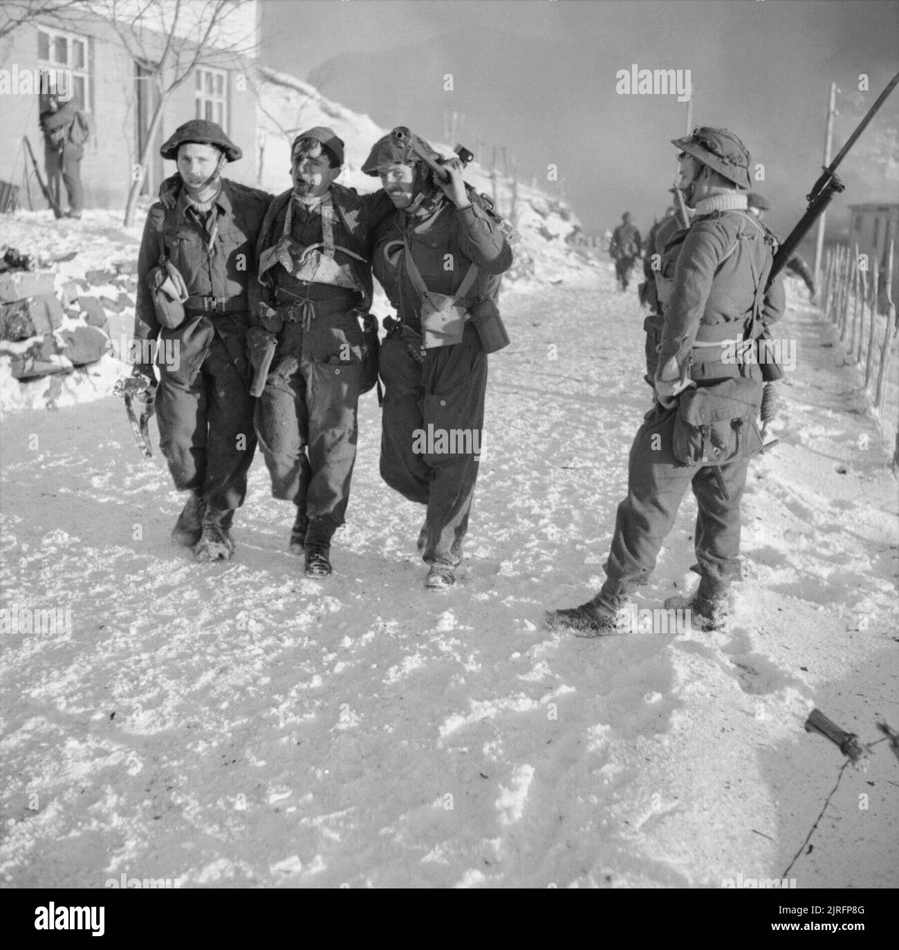 A wounded British officer being helped through the snow to a dressing ...