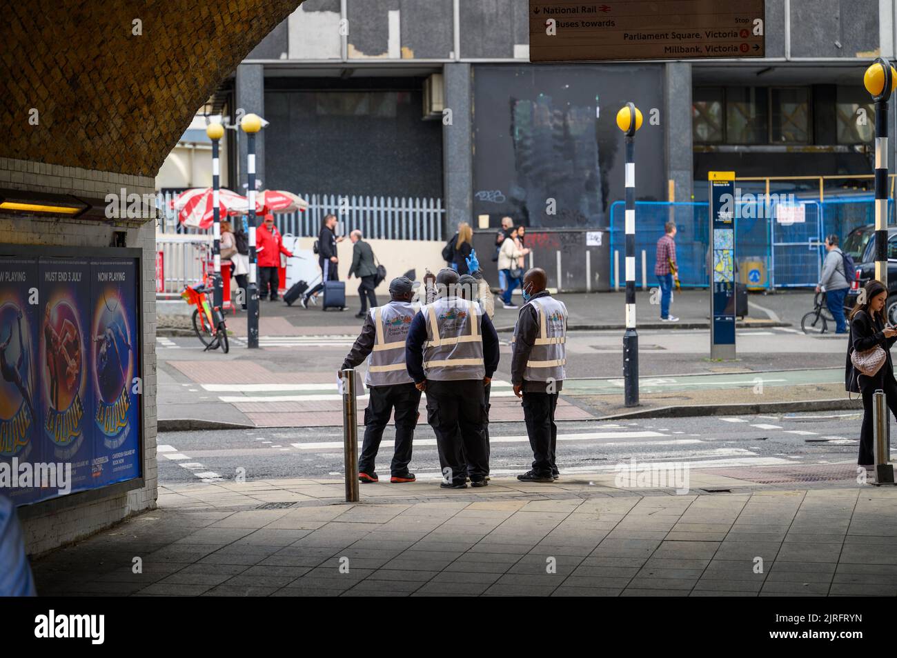 LONDON - May 20, 2022: Team of street cleaners stood at zebra crossing ...