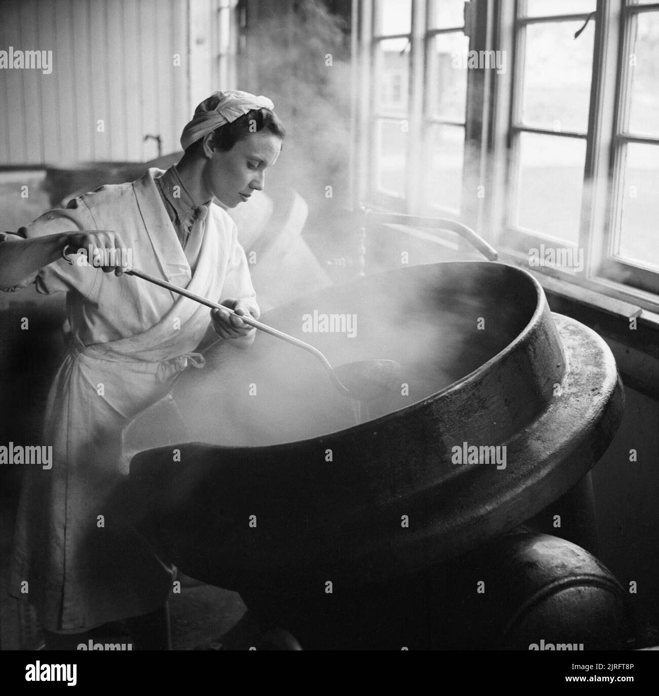 An Auxiliary Territorial Service (ATS) cook at work in an army ...