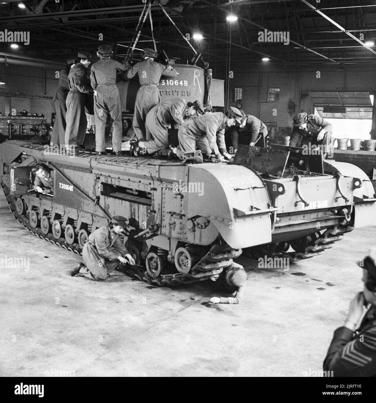 Auxiliary Territorial Service (ATS) women working on a Churchill tank ...
