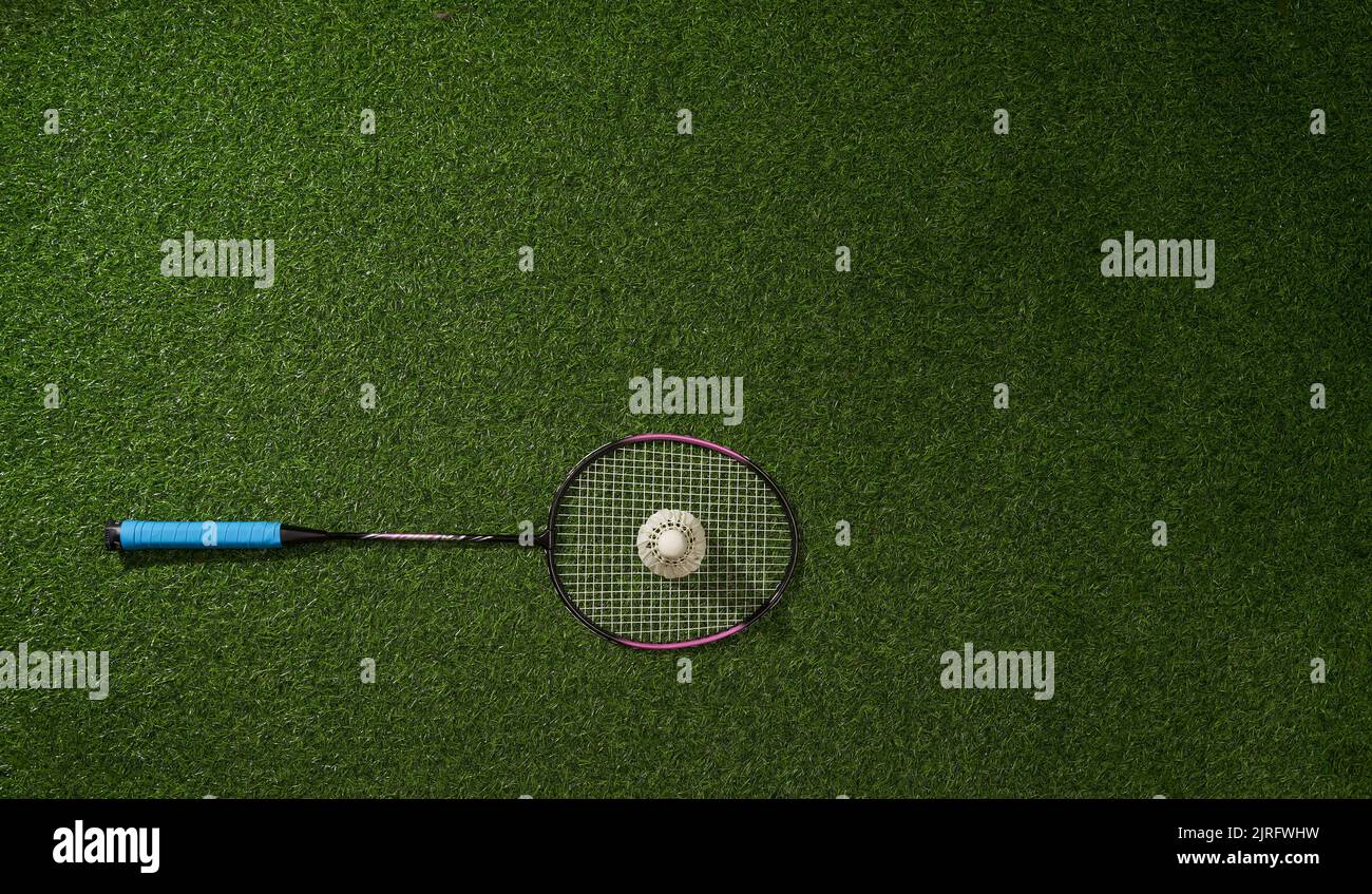 Badminton racket and shuttlecock on green grass background. Concept of ...