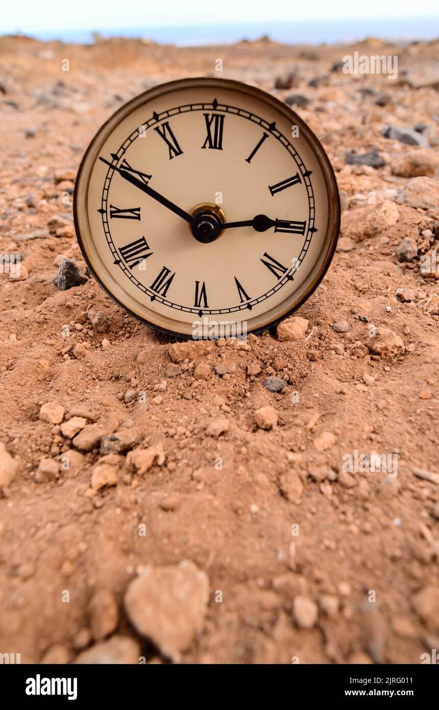 Classic Analog Clock In The Sand On The Rock Desert Stock Photo - Alamy