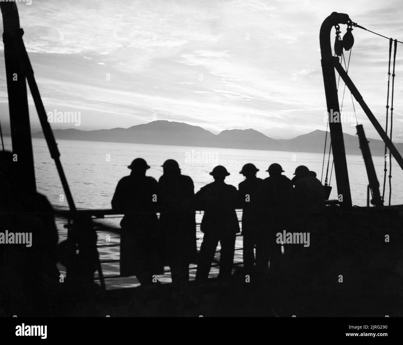 British troops on board a troop ship watching the sunset off the ...