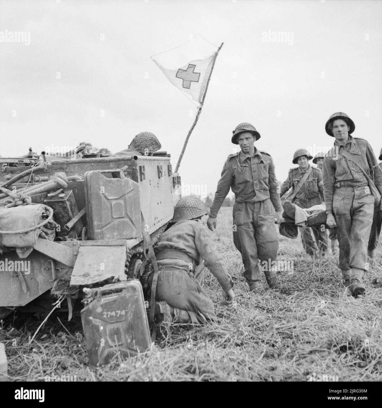 A British casualty is brought back to a Universal Carrier being used to ...