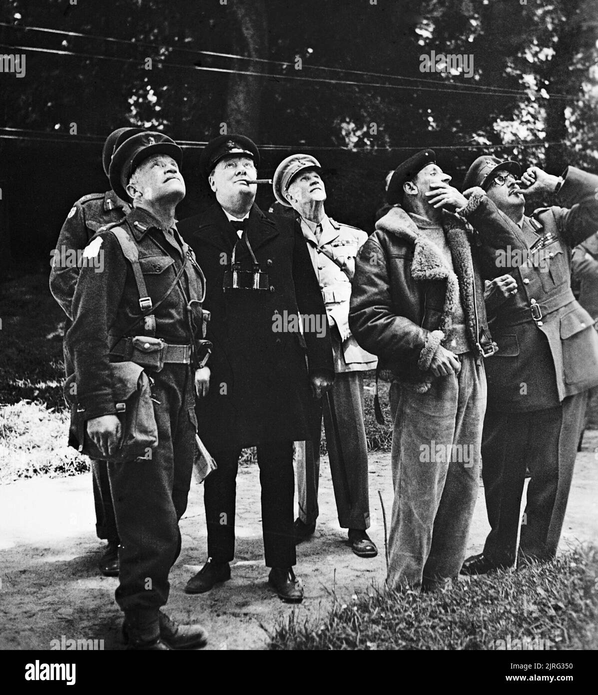 Winston Churchill and senior Allied commanders looking up at aircraft ...