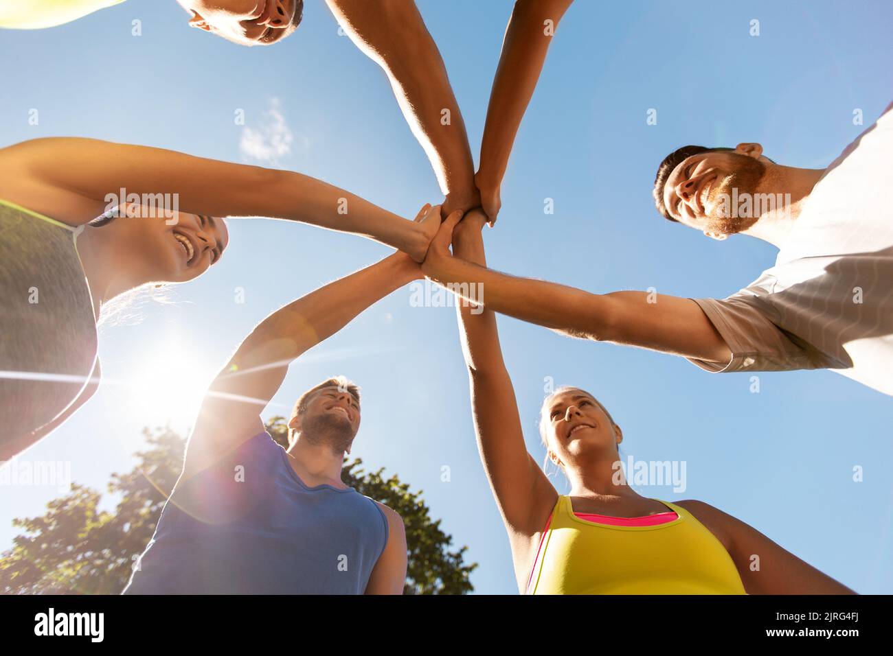 group of happy sporty friends making high five Stock Photo - Alamy