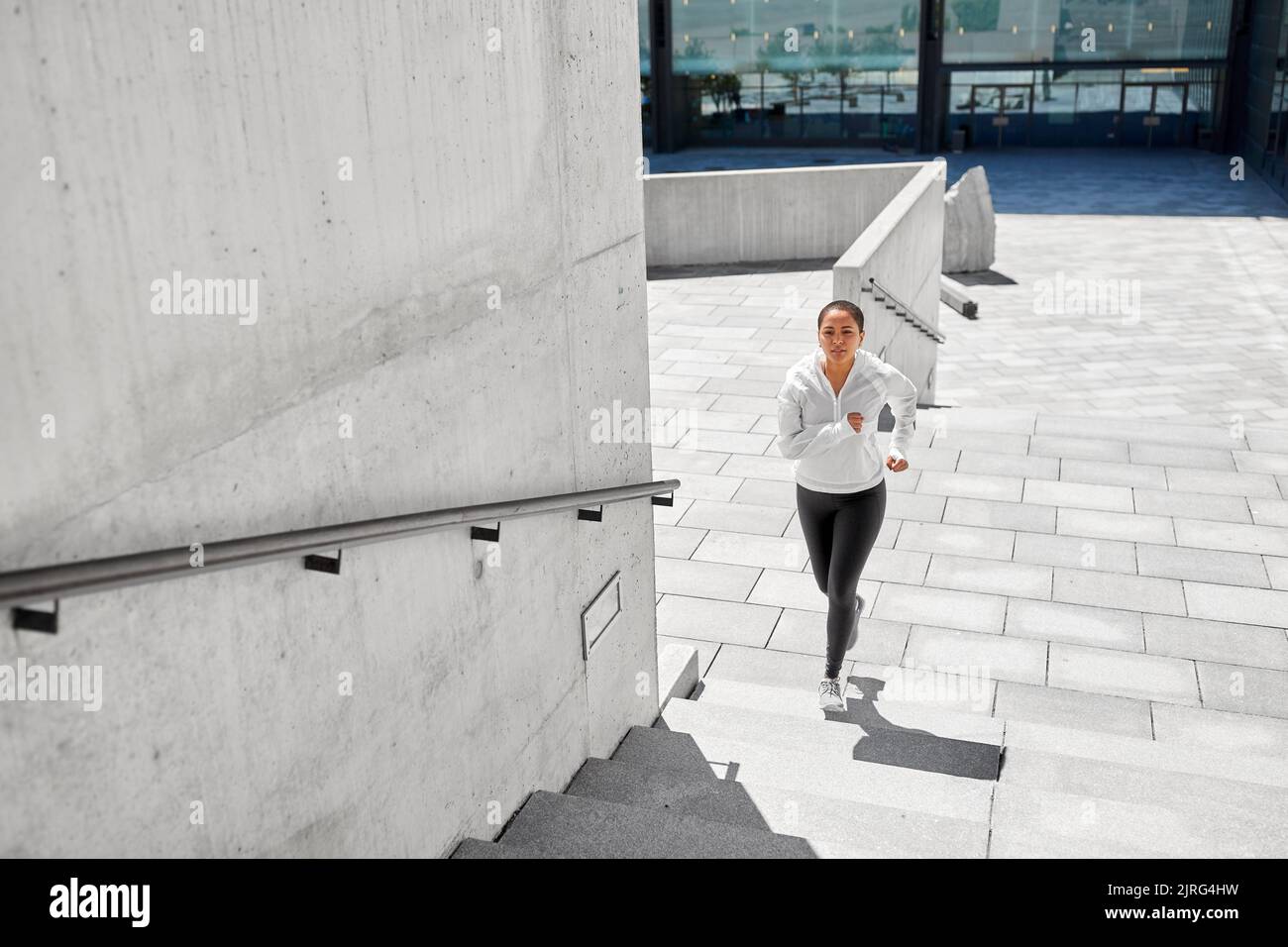 african american woman running upstairs outdoors Stock Photo - Alamy