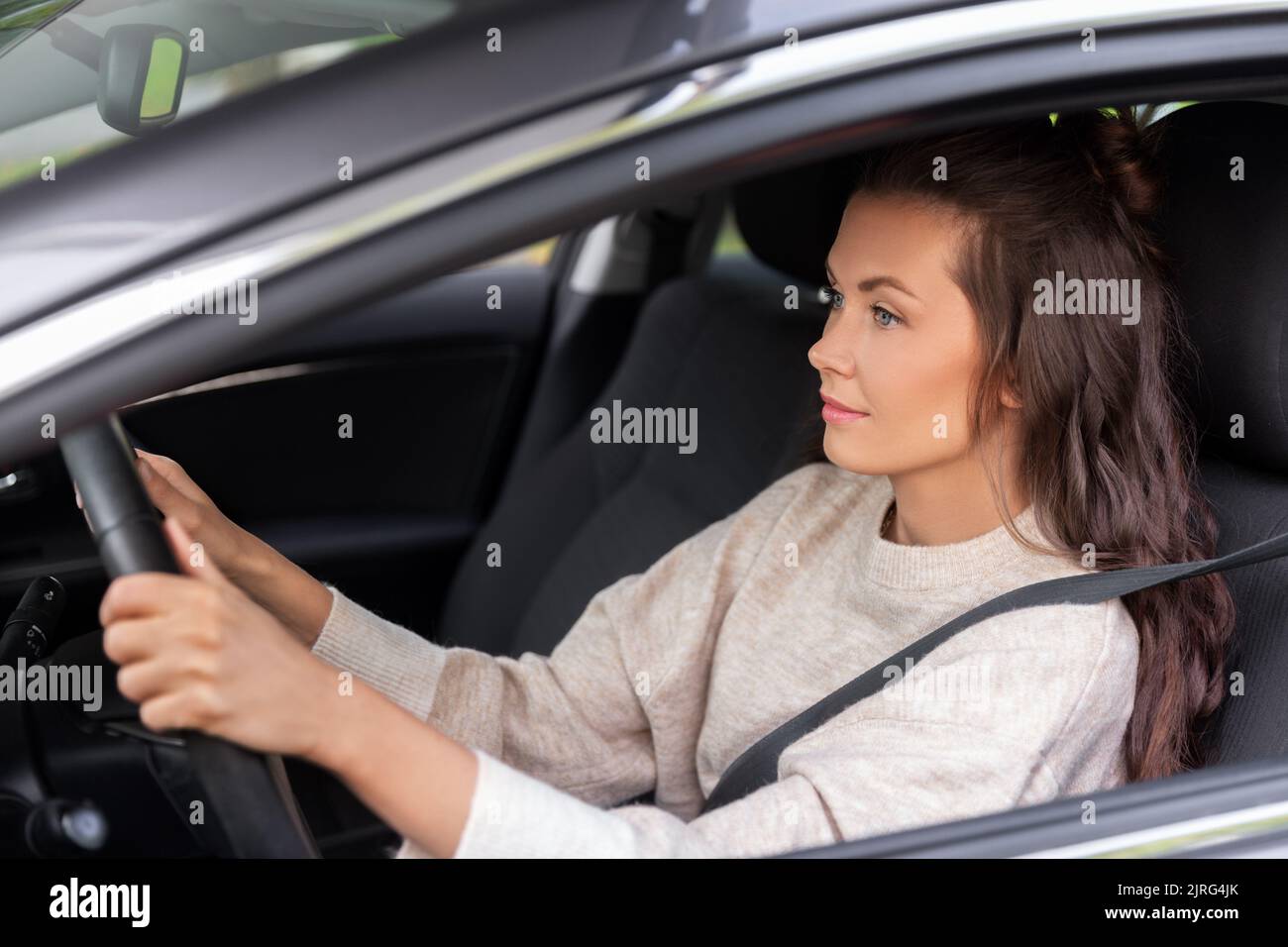 woman or female driver driving car in city Stock Photo - Alamy