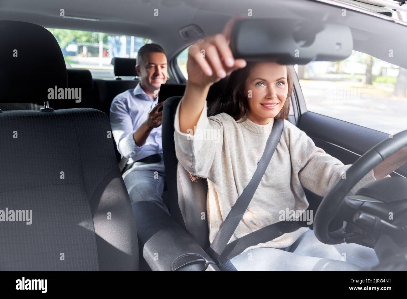 female driver driving car with male passenger Stock Photo - Alamy