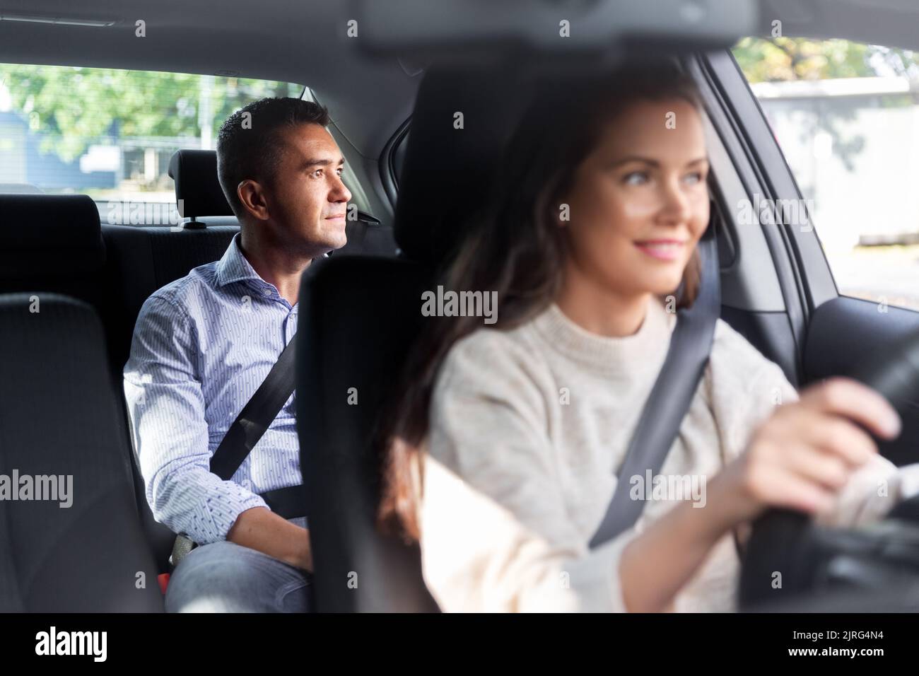 female driver driving car with male passenger Stock Photo - Alamy