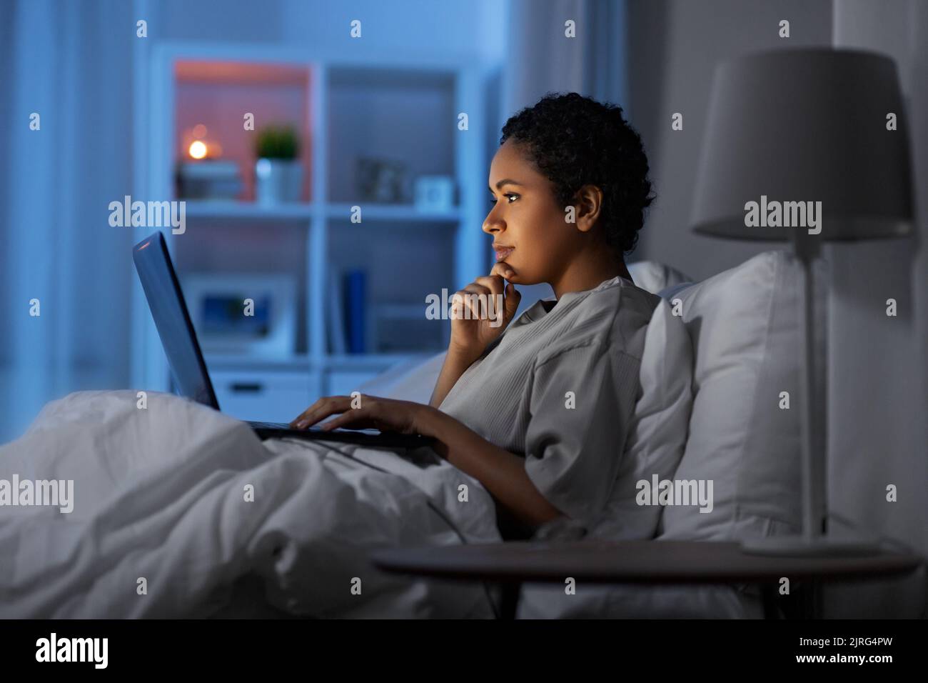 woman with laptop in bed at home at night Stock Photo - Alamy