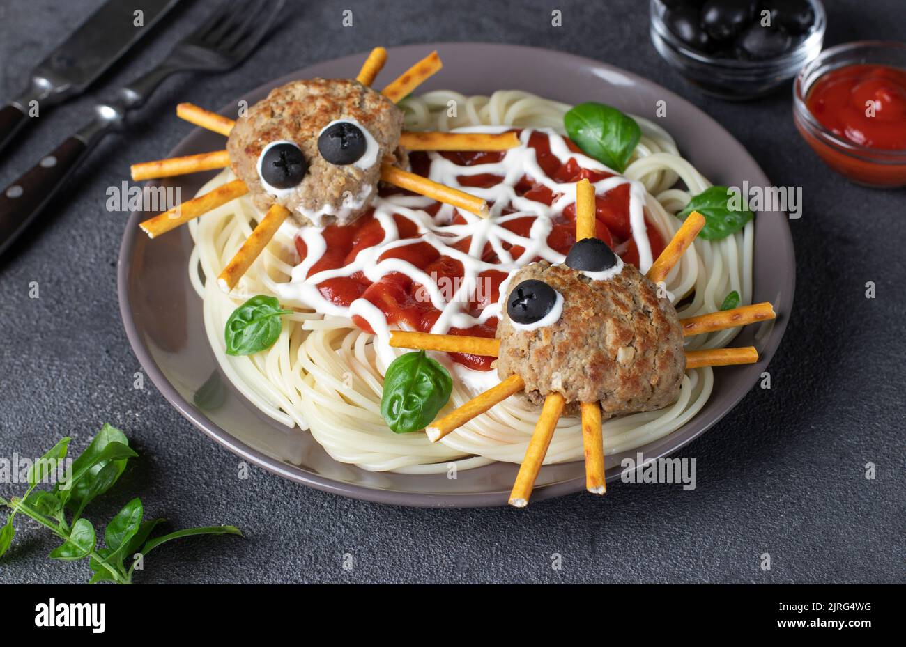 Cutlets look like a spiders with olives and straws, served with ...