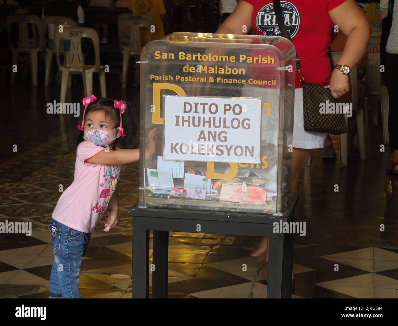 Malabon, Philippines. 24th Aug, 2022. A young girl holding a transparent collection box inside ...