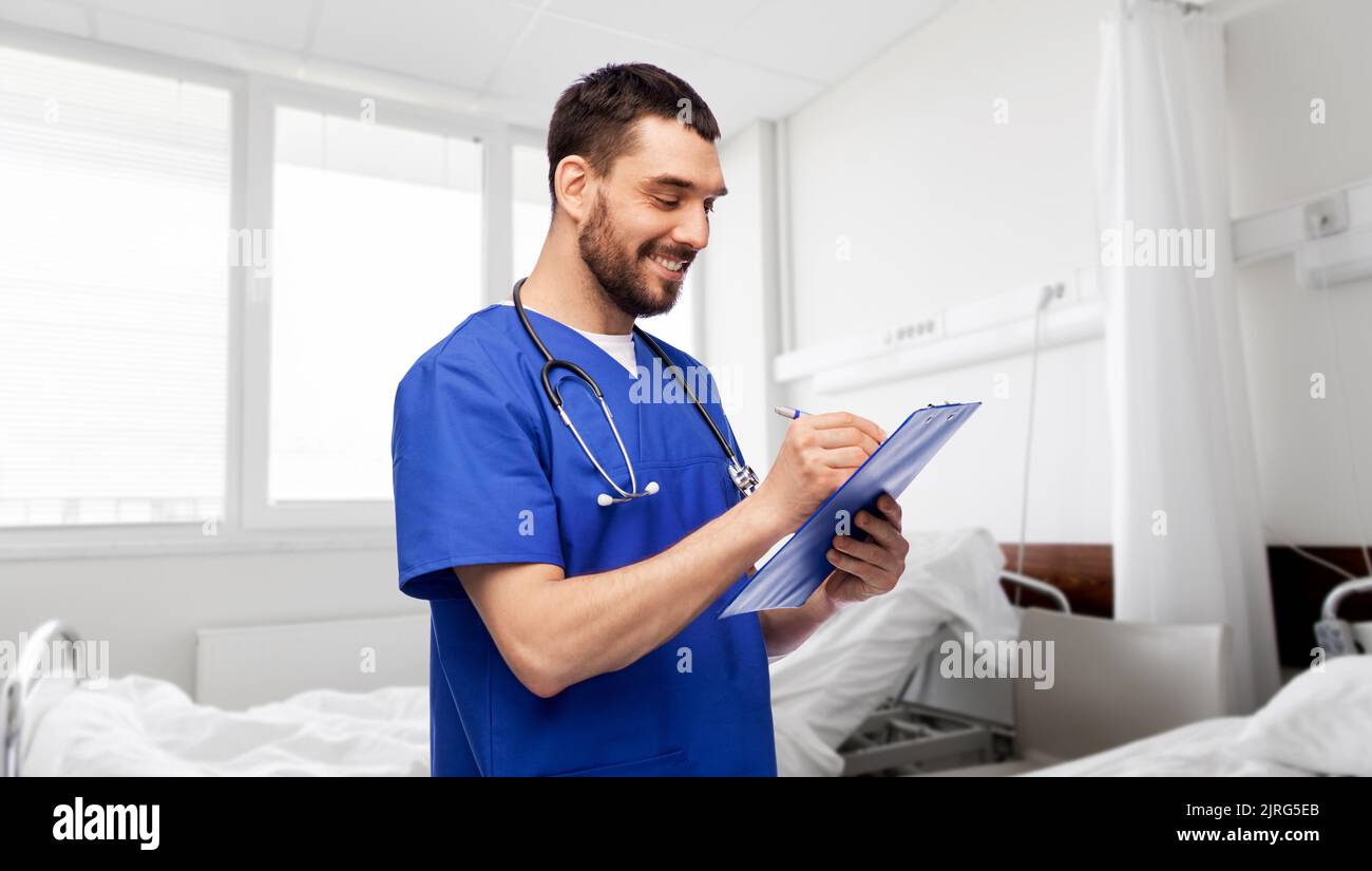 male doctor writing medical report on clipboard Stock Photo - Alamy