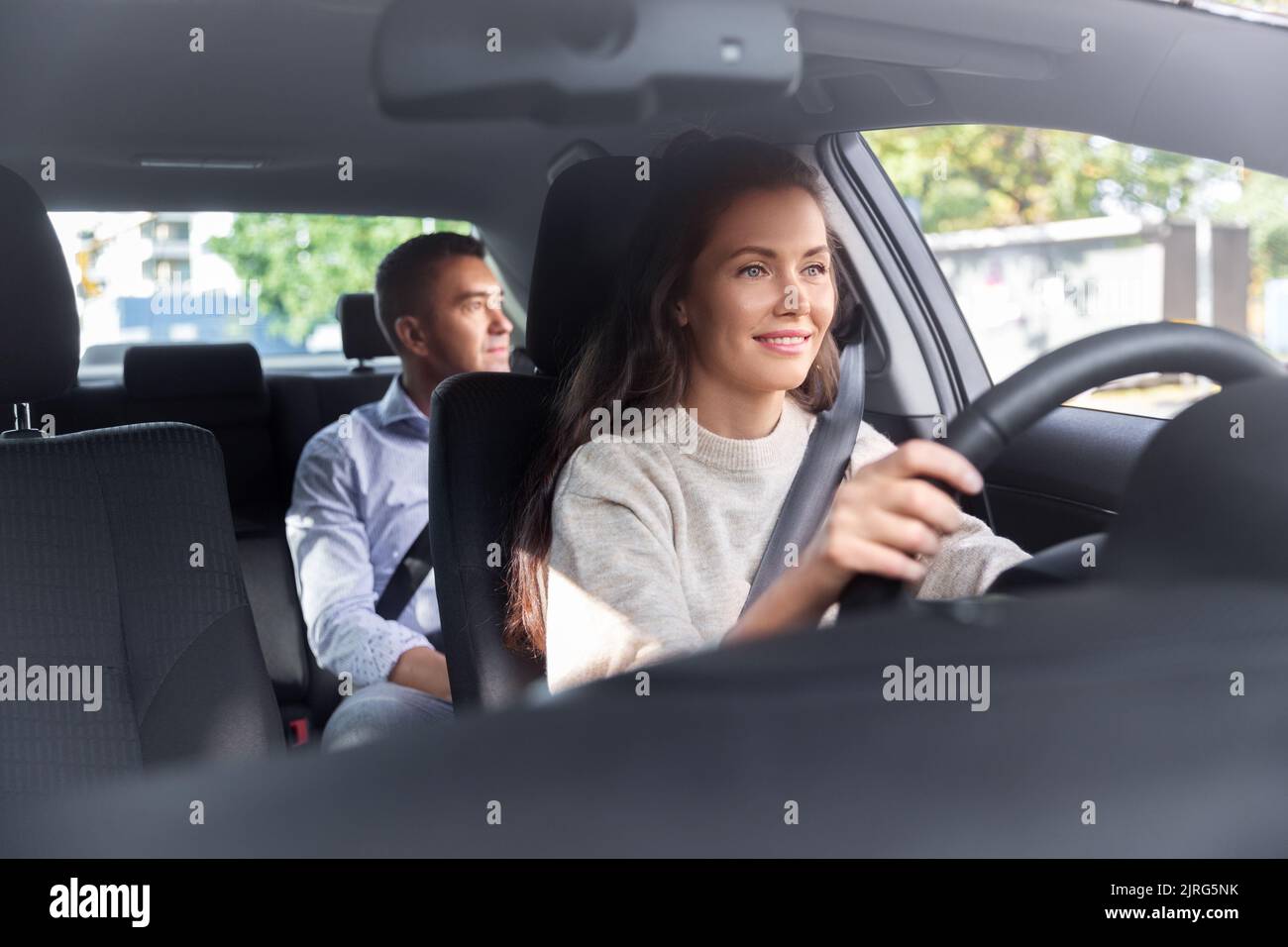 female driver driving car with male passenger Stock Photo - Alamy