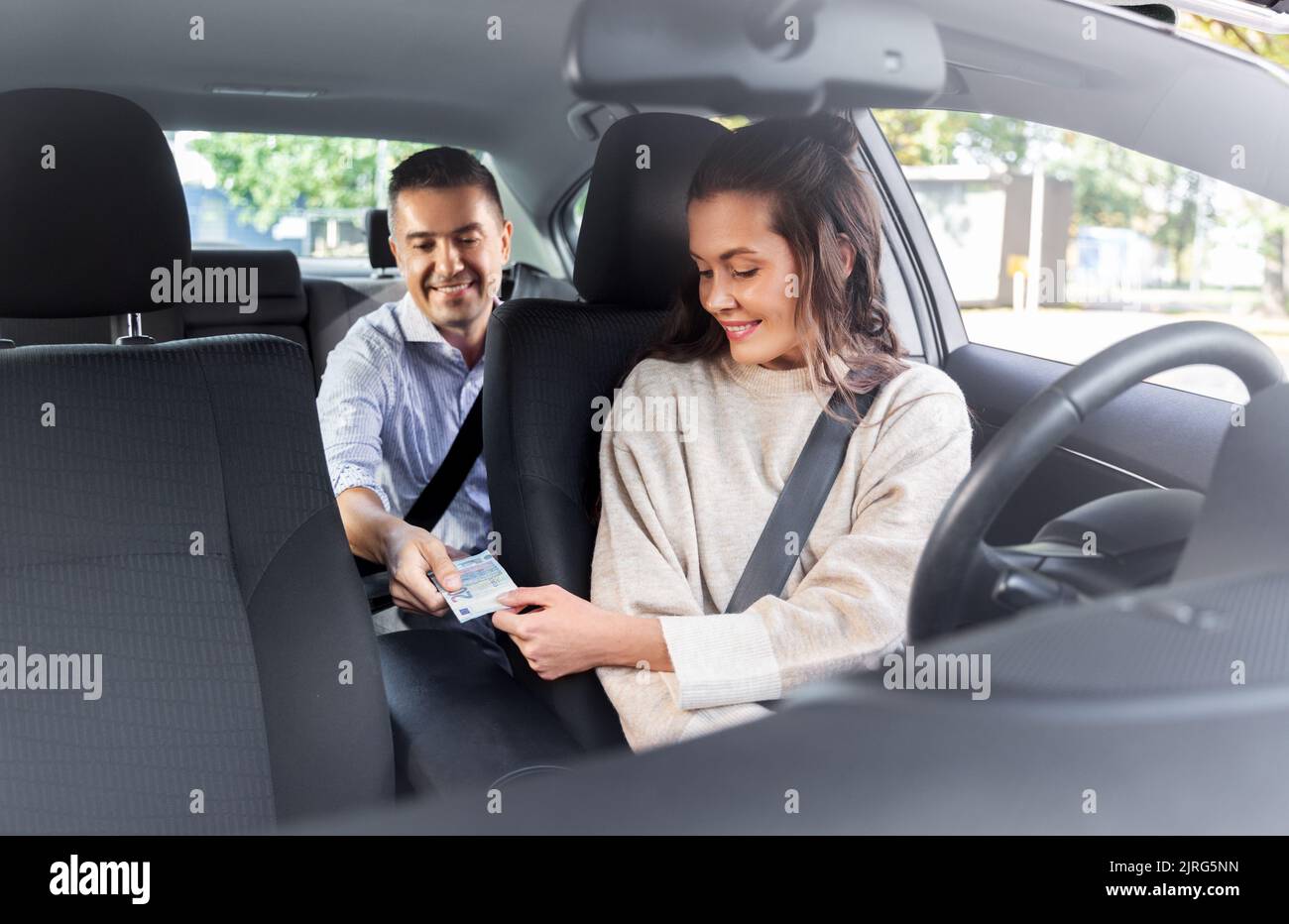 female car driver taking money from passenger Stock Photo - Alamy
