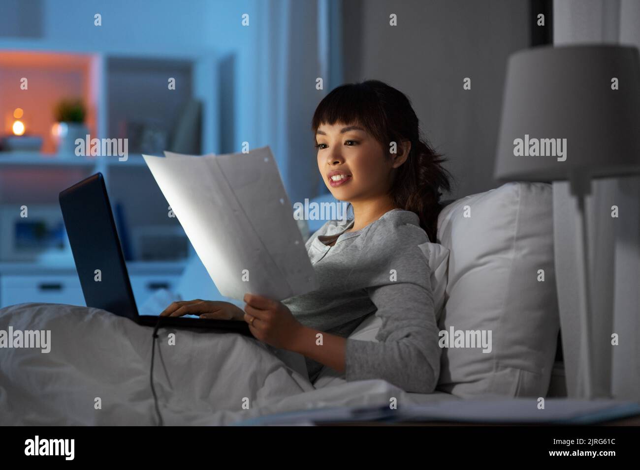 woman with laptop working in bed at night Stock Photo - Alamy