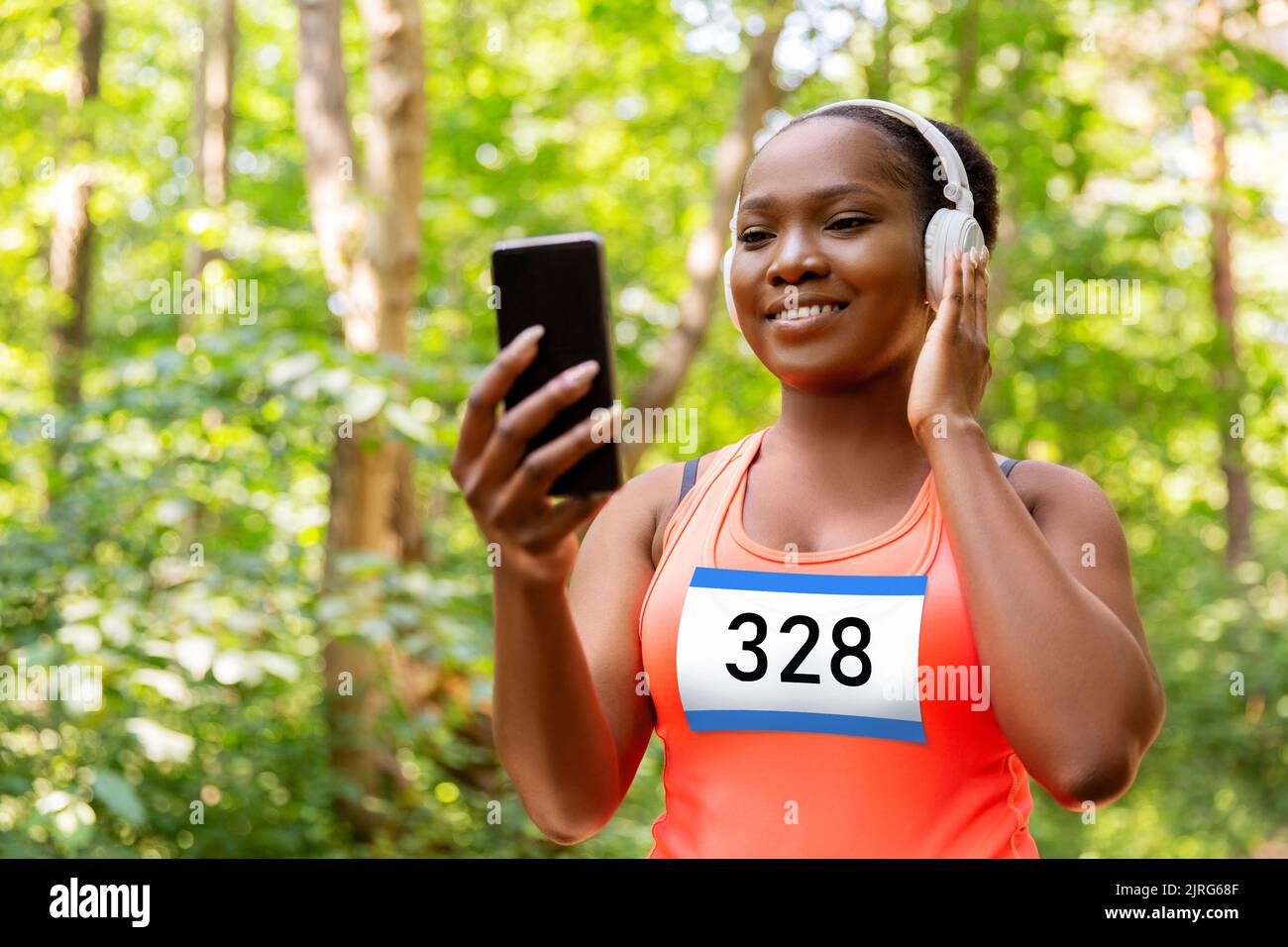 female marathon runner with headphones and phone Stock Photo - Alamy