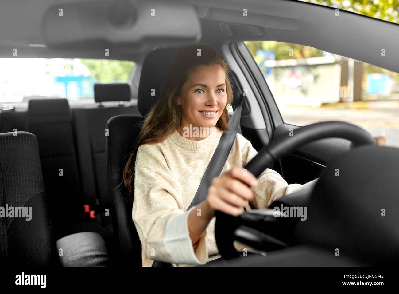 smiling woman or female driver driving car in city Stock Photo - Alamy