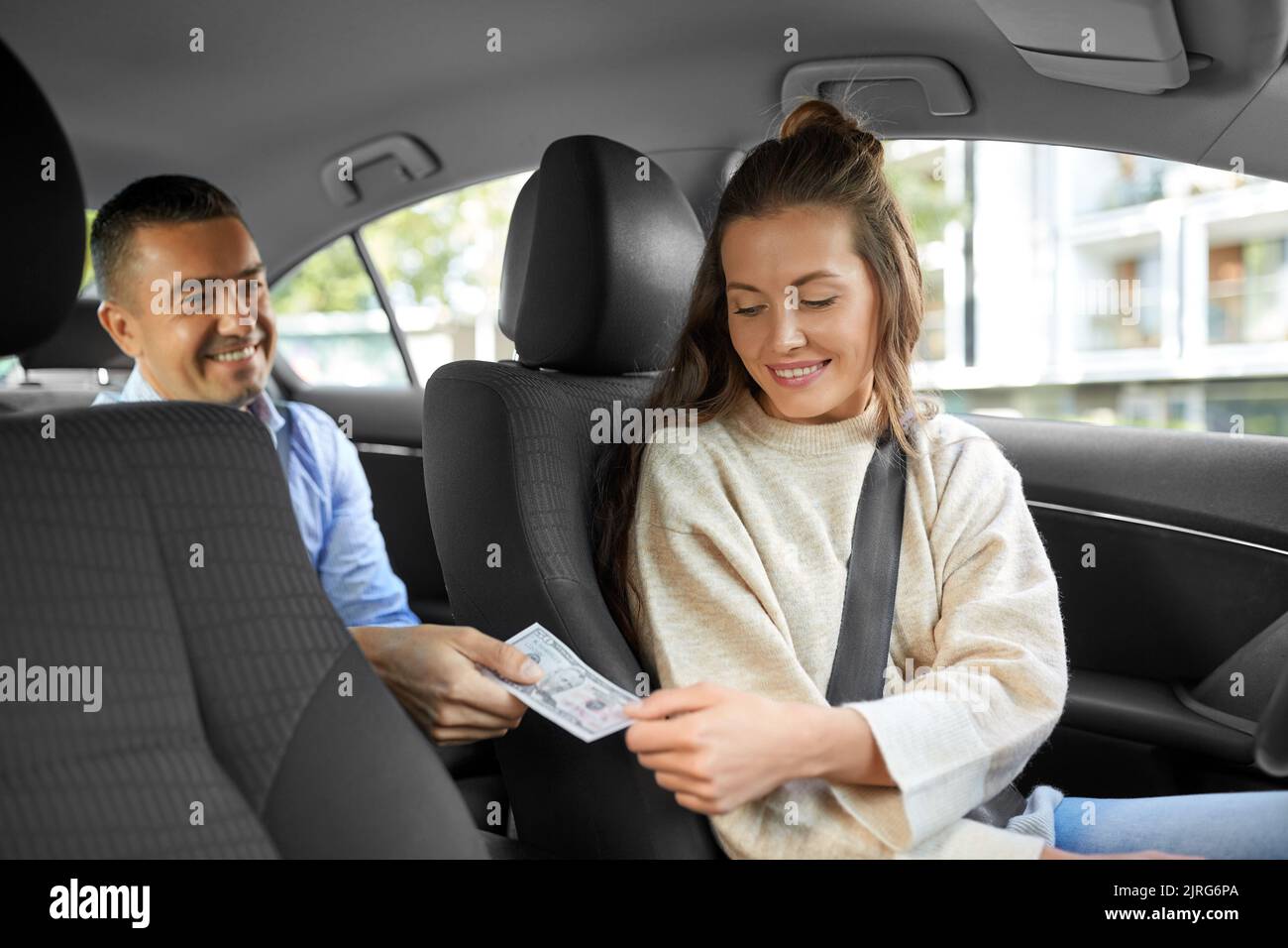 female car driver taking money from passenger Stock Photo - Alamy